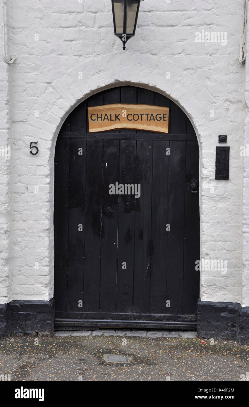 arched wooden door chalk cottage sign Stock Photo - Alamy