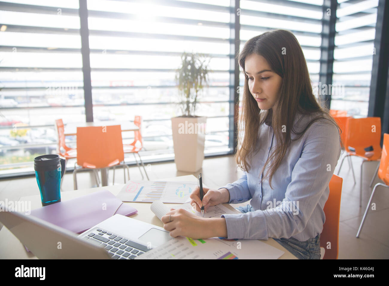 Portrait of young overworked woman creating new project for work Stock ...