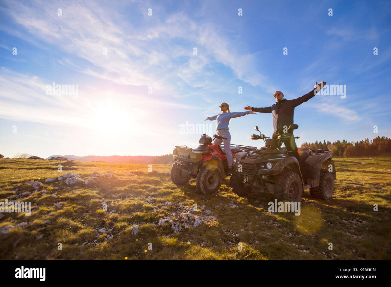 Couple driving off-road with quad bike or ATV Stock Photo - Alamy