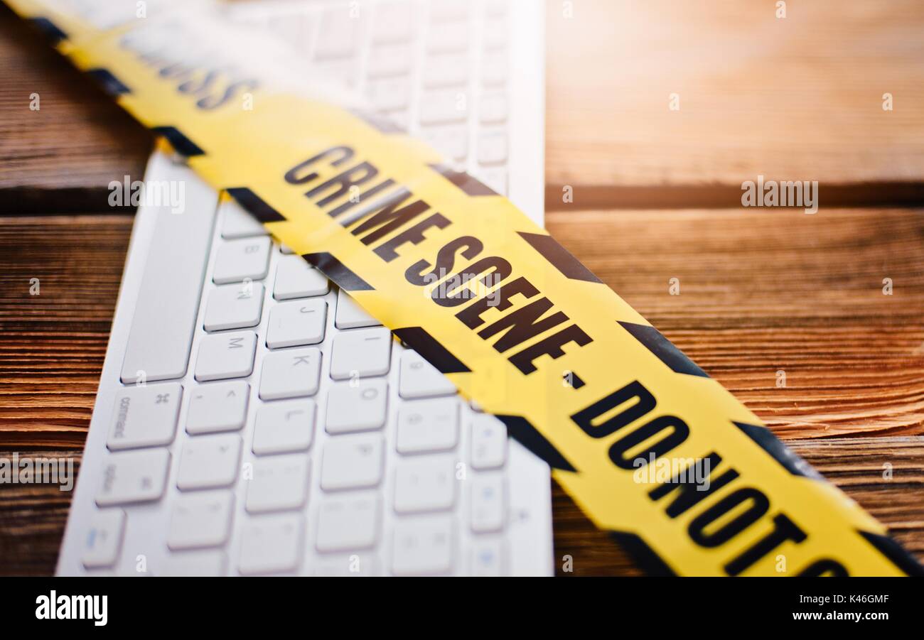 Yellow crime scene tape on computer keyboard. Computer crime concept ...