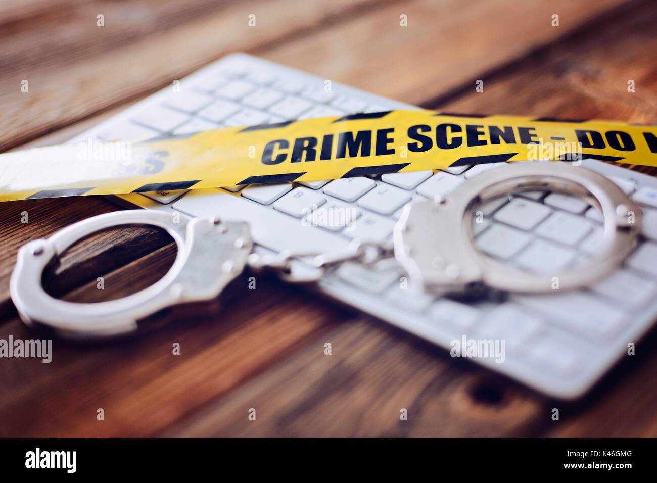 Yellow crime scene tape and handcuffs on computer keyboard. Computer ...