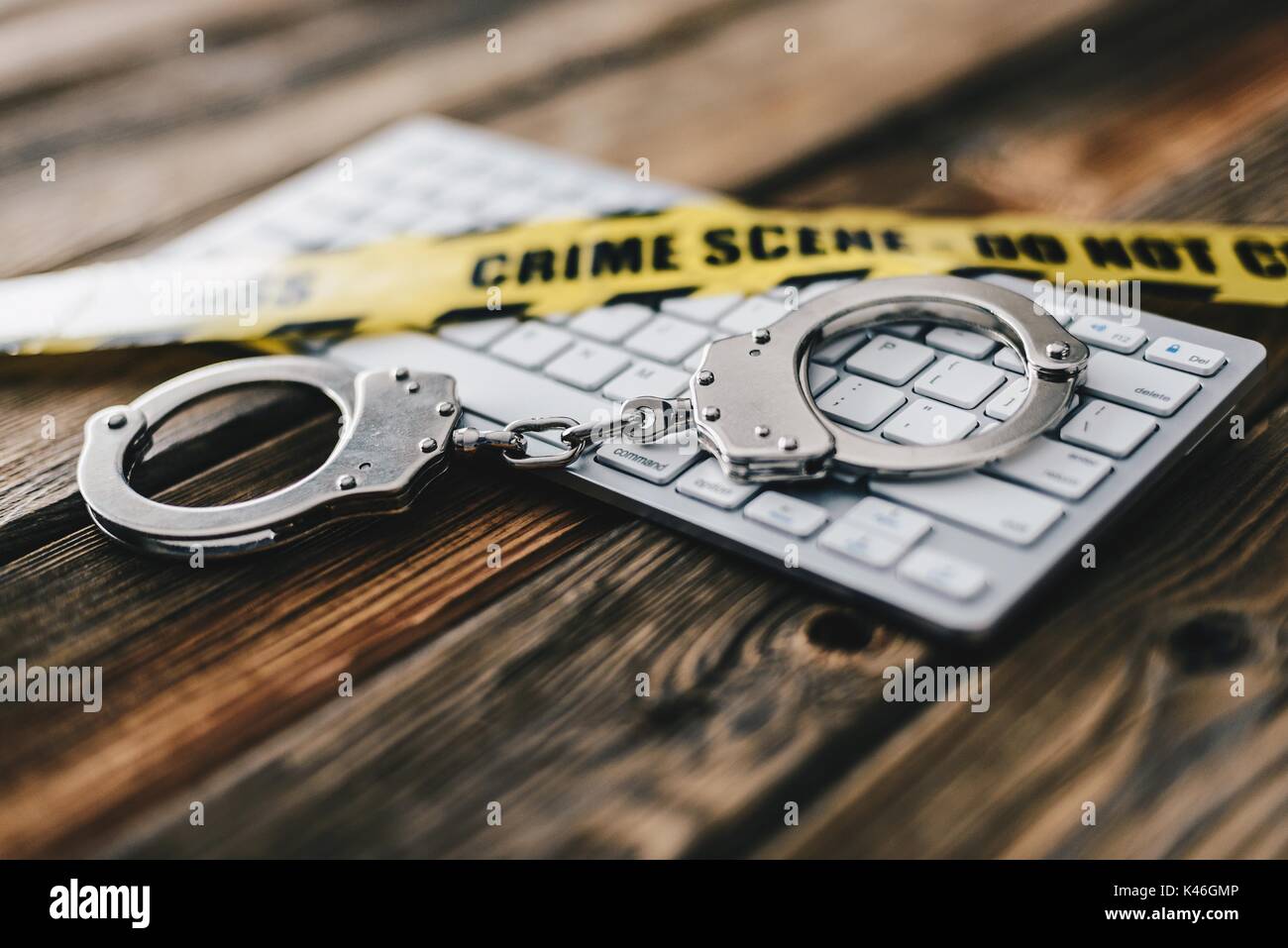 Yellow crime scene tape and handcuffs on computer keyboard. Computer ...