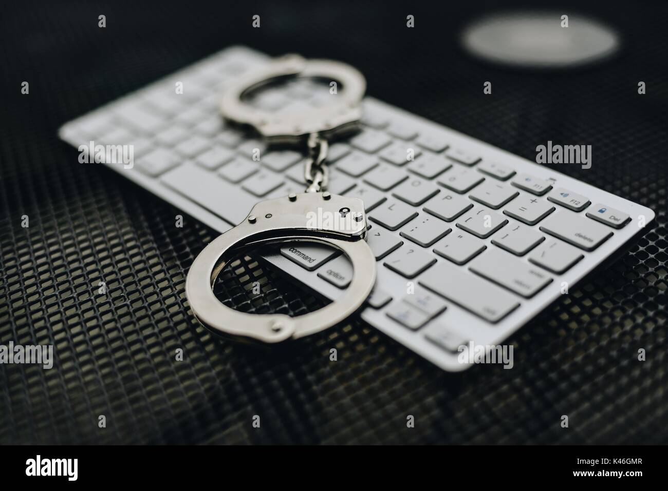 Handcuffs on computer keyboard. Computer crime concept Stock Photo - Alamy