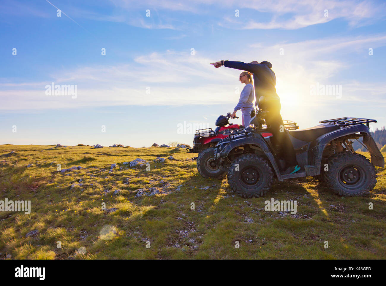 Couple driving off-road with quad bike or ATV Stock Photo - Alamy
