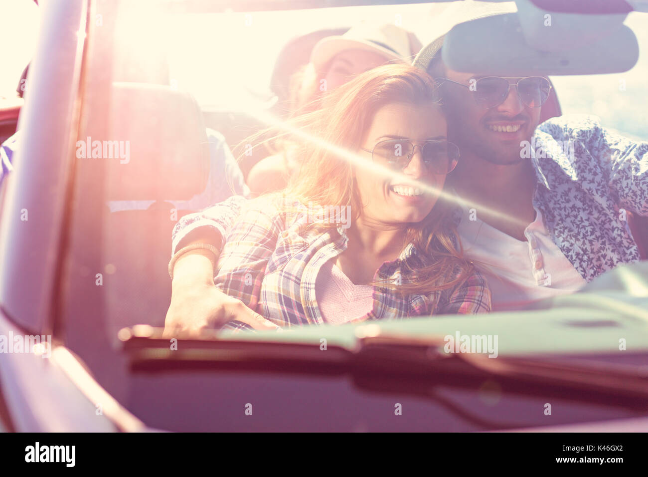 Couple with friends driving in the sunset Stock Photo - Alamy