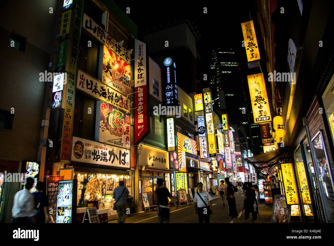 Shinjuku shops at night with its neon lights trying to draw in local ...