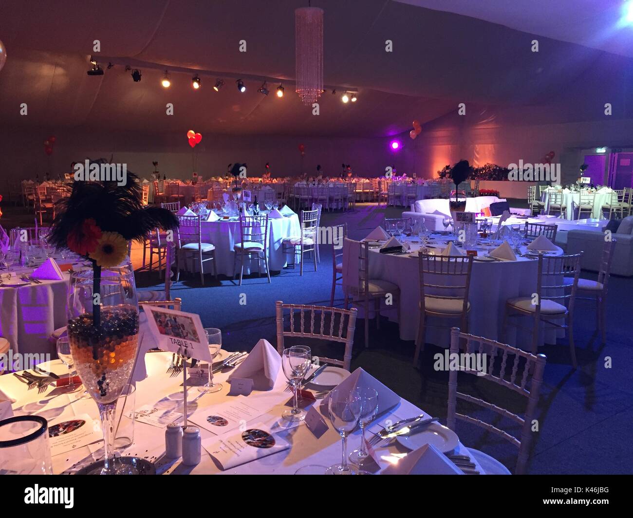 Ballroom set up ready for charity ball with an orange and black theme ...