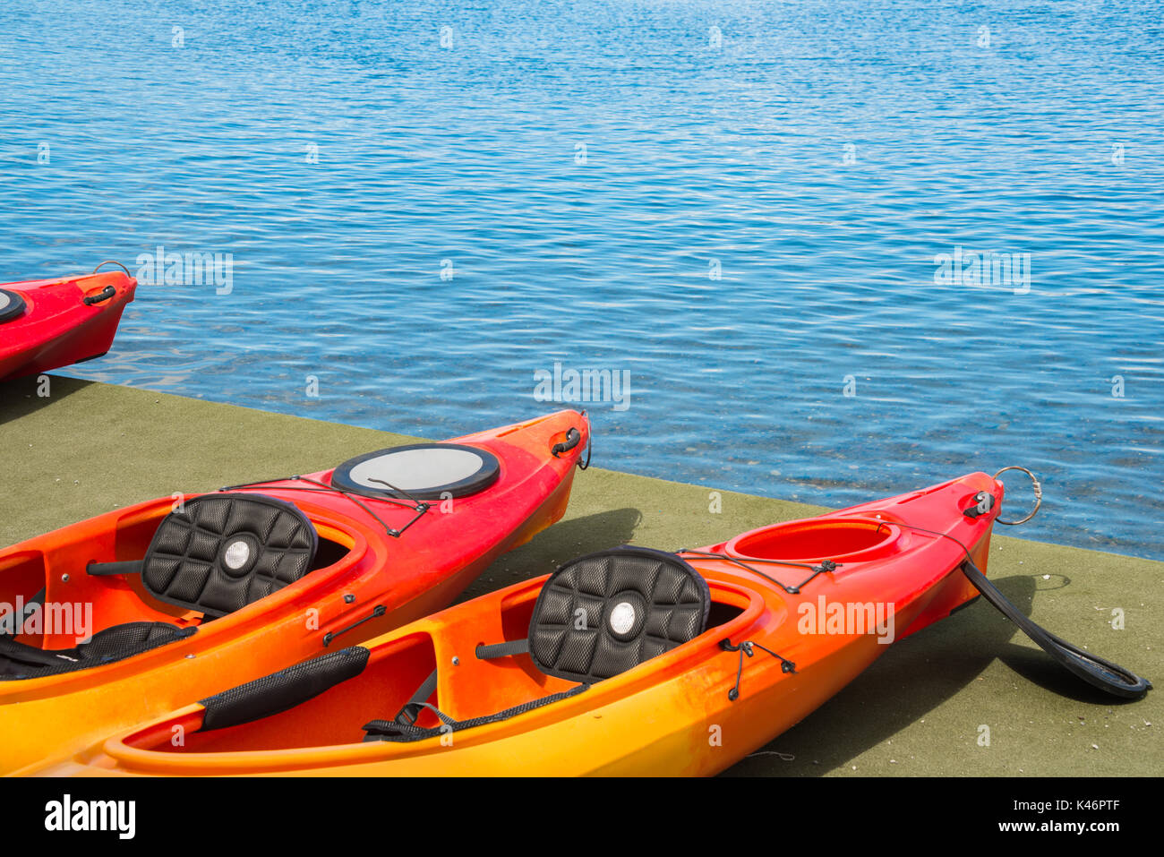Bright Colorful Orange and Yellow Plastic Kayaks Detail on Edge of Blue ...