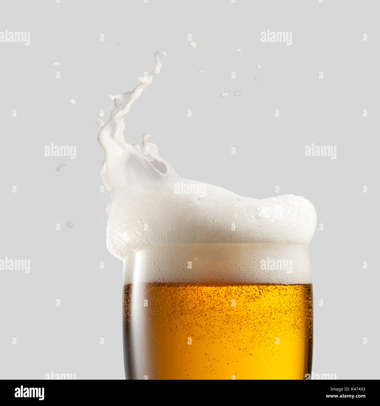 Close-up of cold beer with foam and splash on a gray background Stock ...