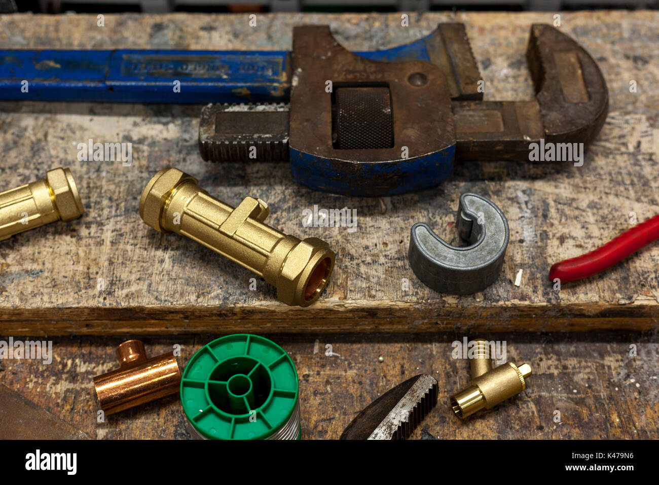 Various types of brass valves and adjustable wrenches on a plumbers old ...