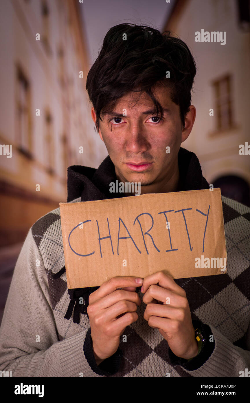 Close up of a homeless with cardboard description of charity, in a ...