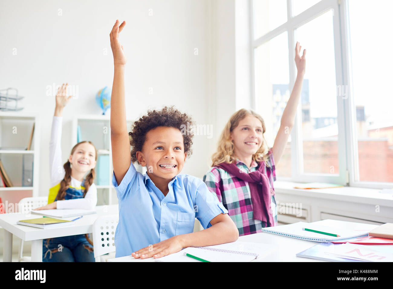 Kids raising hands classroom hi-res stock photography and images - Alamy
