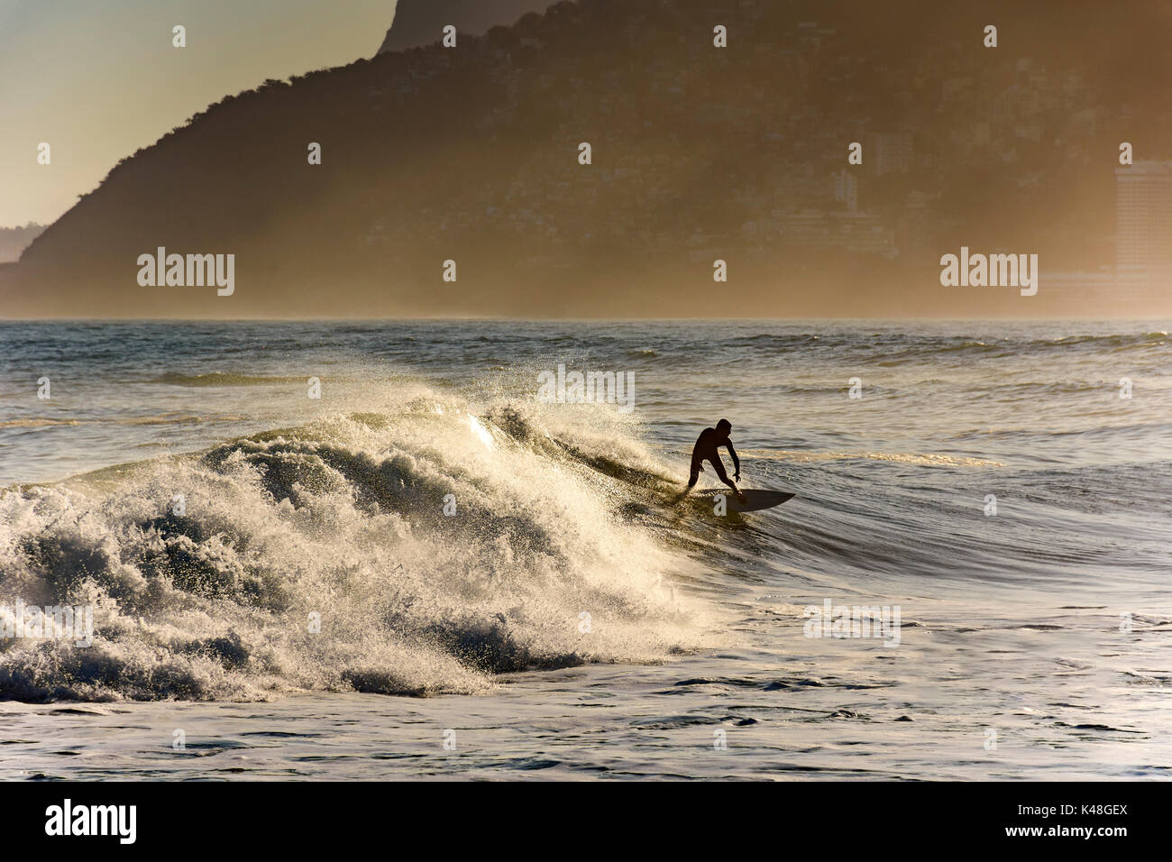 Surfer alone on the beach of Ipanema in Rio de Janeiro during the late ...