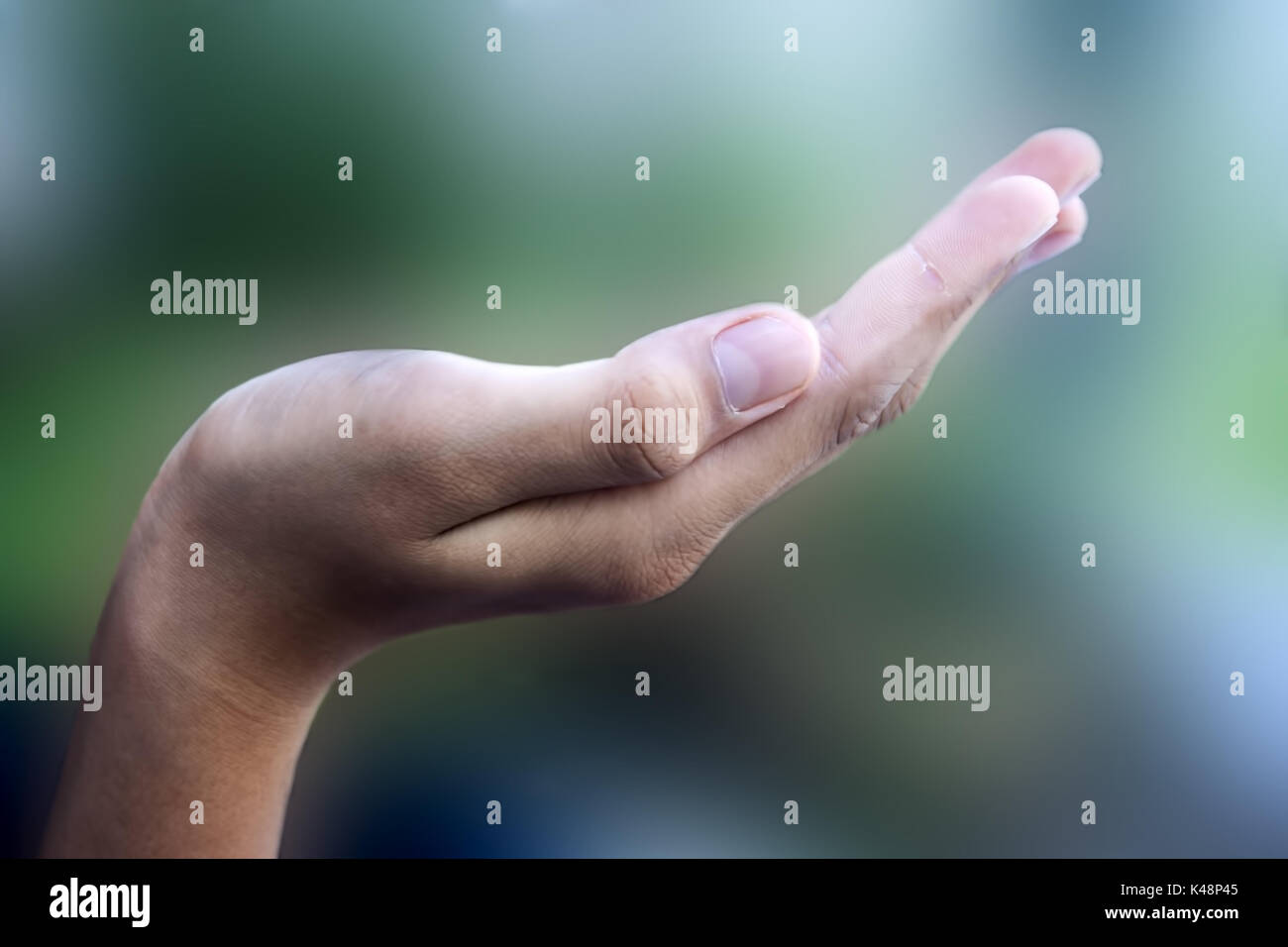 a hand shot in green background Stock Photo - Alamy