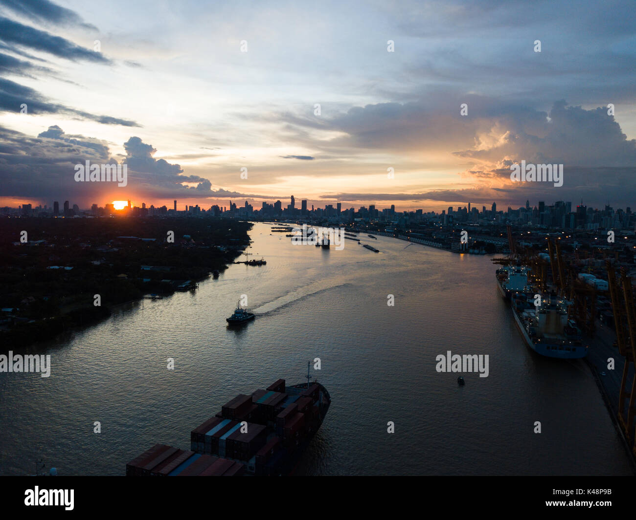 Cargo ship in the harbor at sunset Stock Photo - Alamy