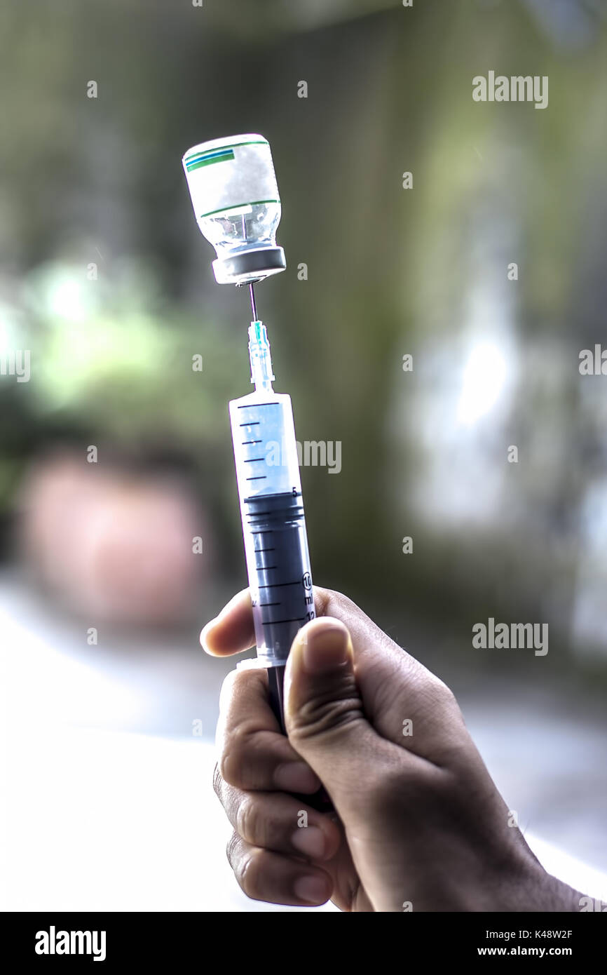 A hand holding injection for virus Stock Photo - Alamy