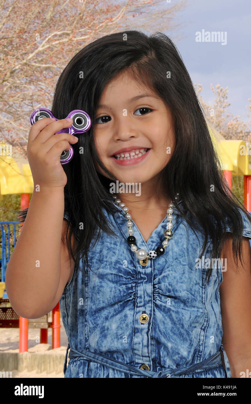 Little girl playing with a fidget spinner Stock Photo - Alamy