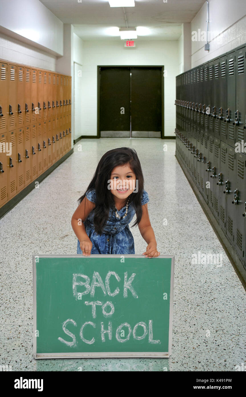 Beautiful little girl holding a back to school sign Stock Photo - Alamy