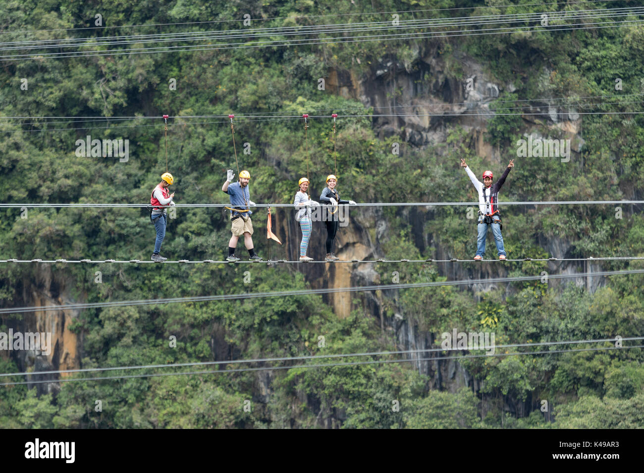 May 29, 2017 Banos, Ecuador: tourists walking a suspended cable bridge ...