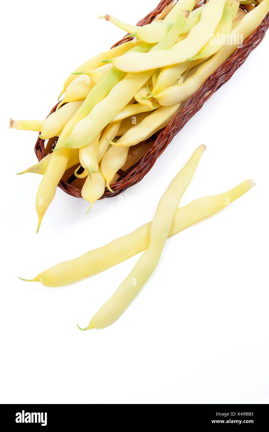 Yellow wooden basket with young pods of beans with beans isolated on ...
