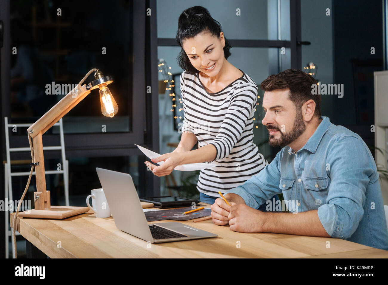 Joyful hard working colleagues looking at the laptop screen Stock Photo ...
