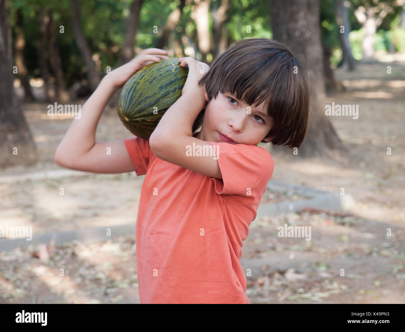 Boychild Carries A Green Melon On His Shoulders Stock Photo - Alamy