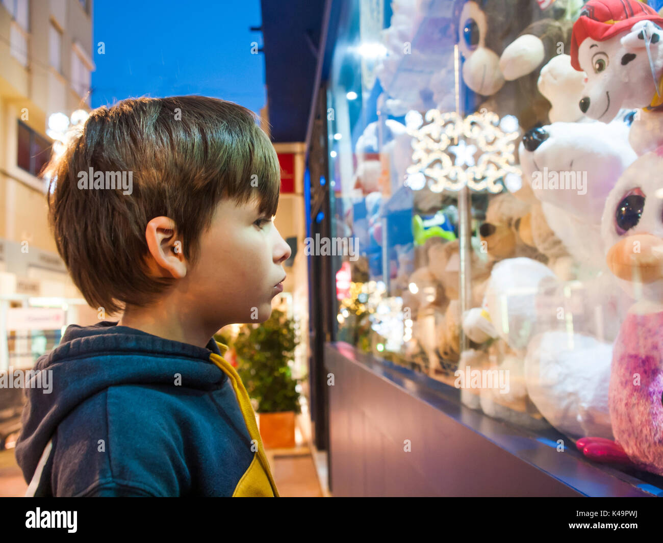 Boy Looks Into The Shop Window Of A Toy Store During Christmas Stock ...