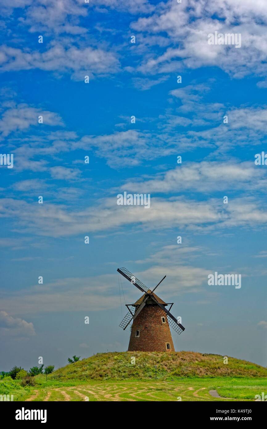 Tower Windmill Stands On A Hill With Blue Sky And Clouds Stock Photo ...
