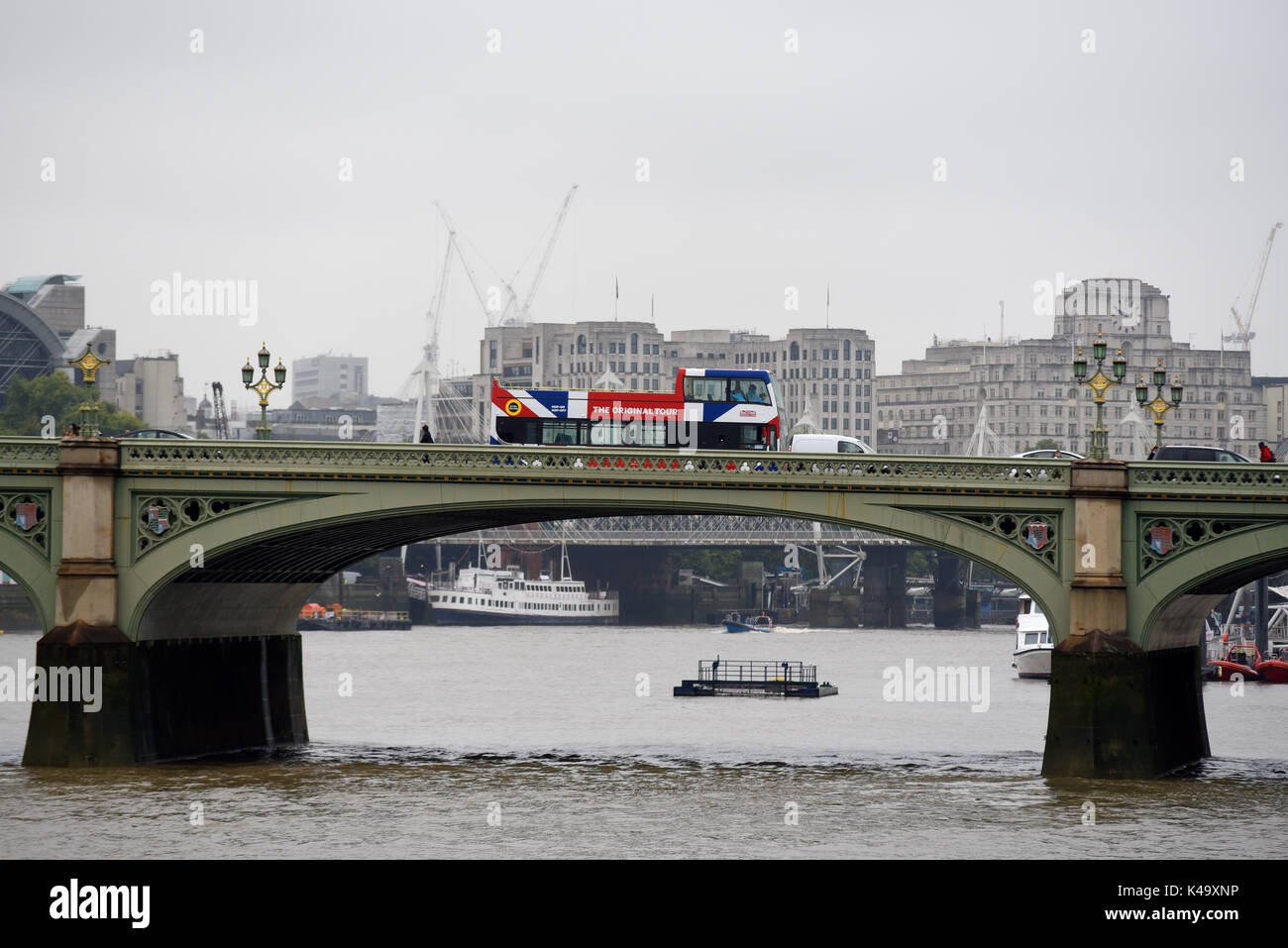 A bus crossing Westminster Bridge London England in dull grey weather ...