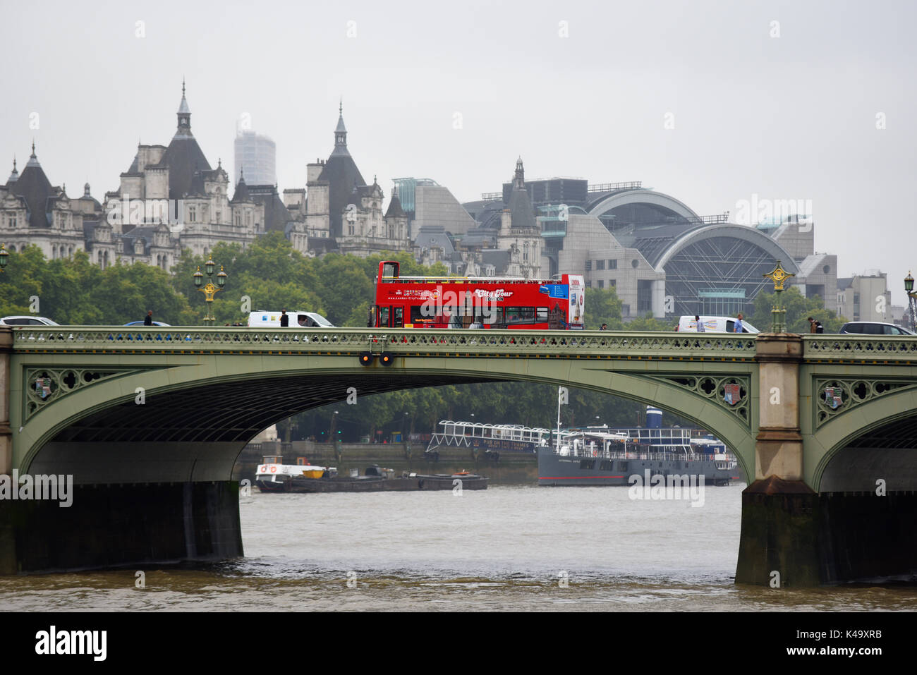 A bus crossing Westminster Bridge London England in dull grey weather ...