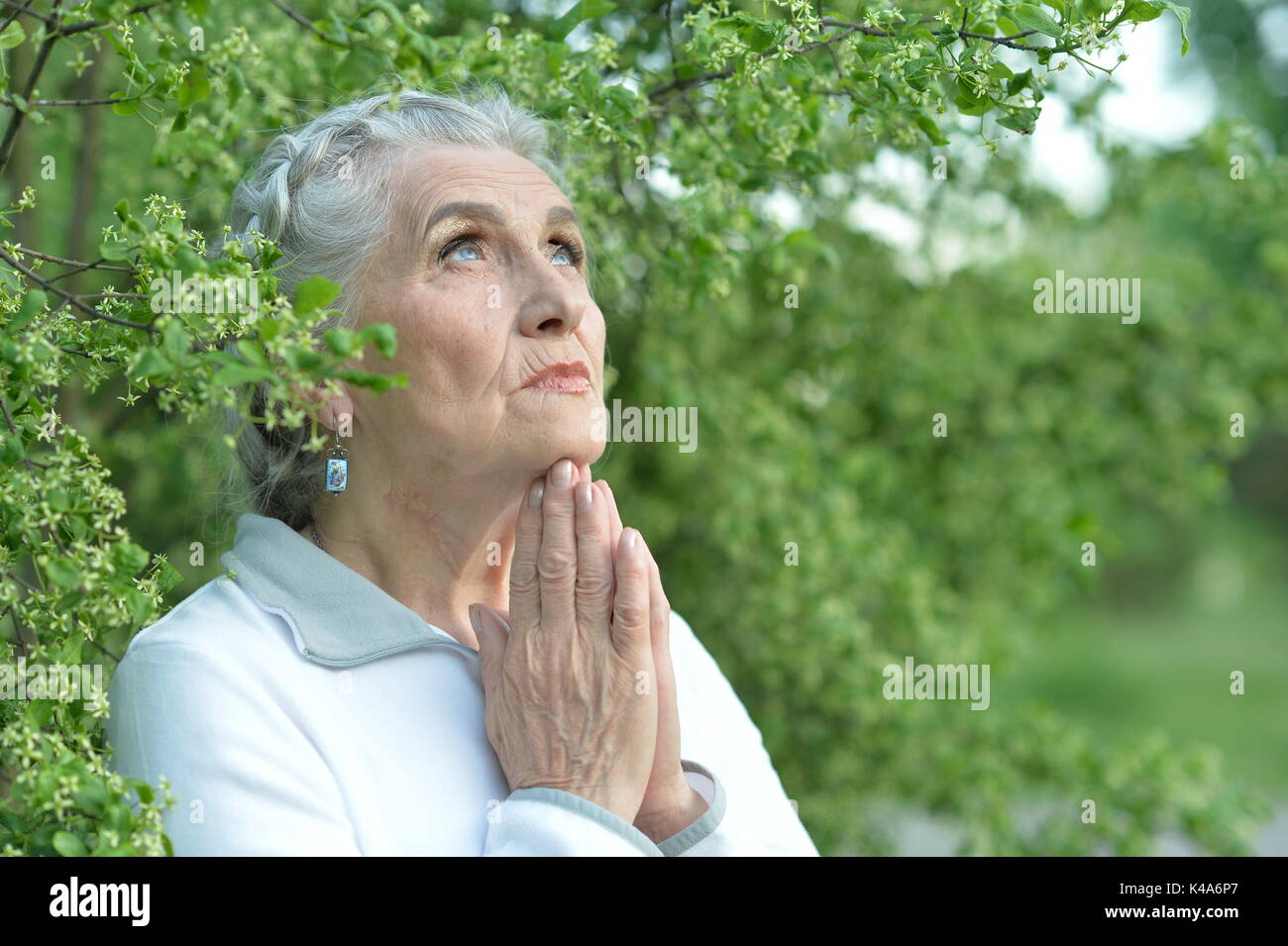 Senior woman praying Stock Photo - Alamy