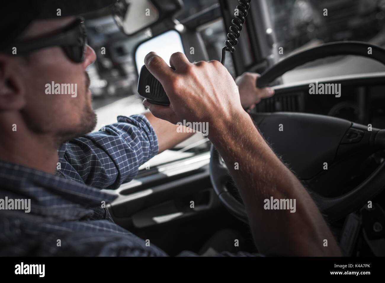 Caucasian Semi Truck Driver Talking on the CB Radio with Other Truckers ...