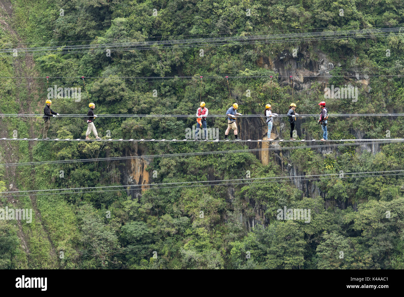 May 29, 2017 Banos, Ecuador: tourists walking a suspended cable bridge ...