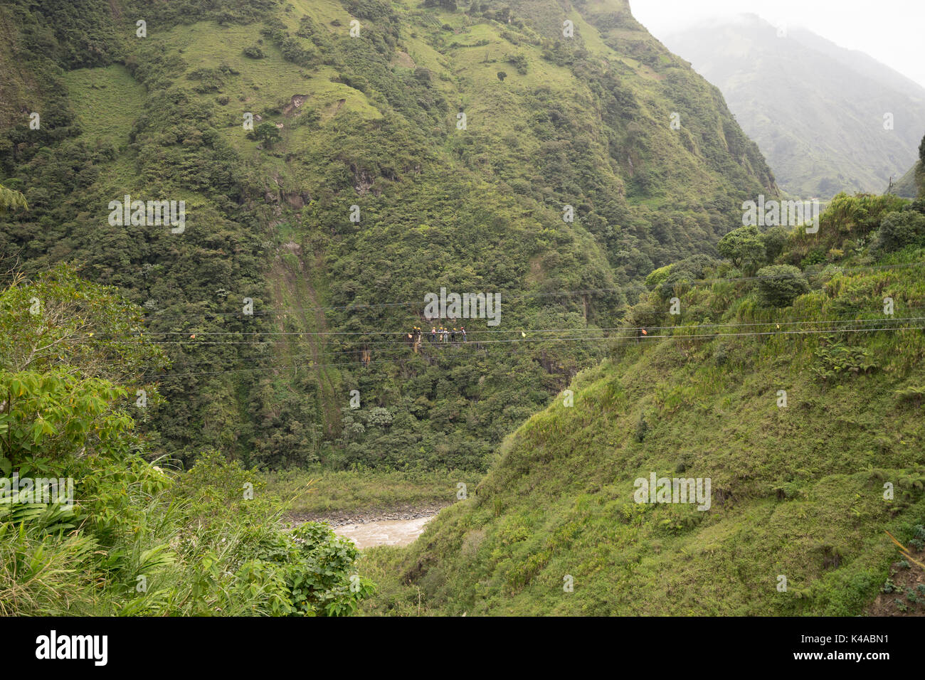 May 29, 2017 Banos, Ecuador: tourists walking a suspended cable bridge ...