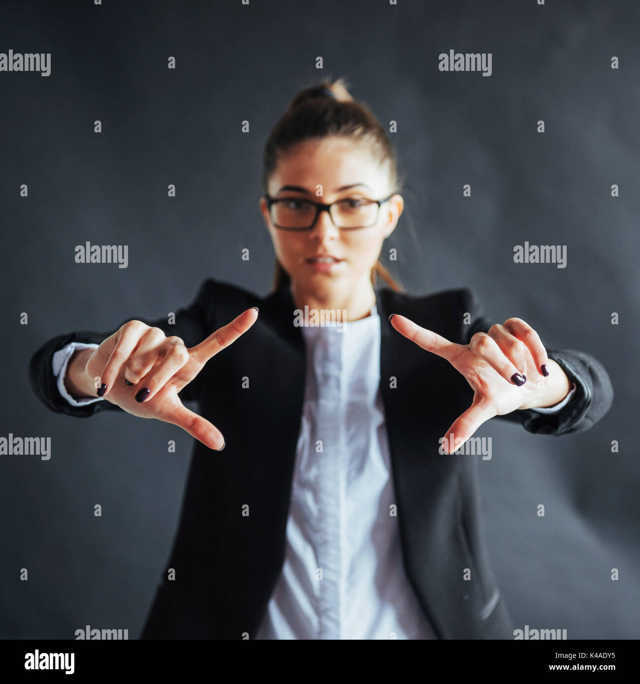 Happy business woman shows finger up, standing on a black background in ...
