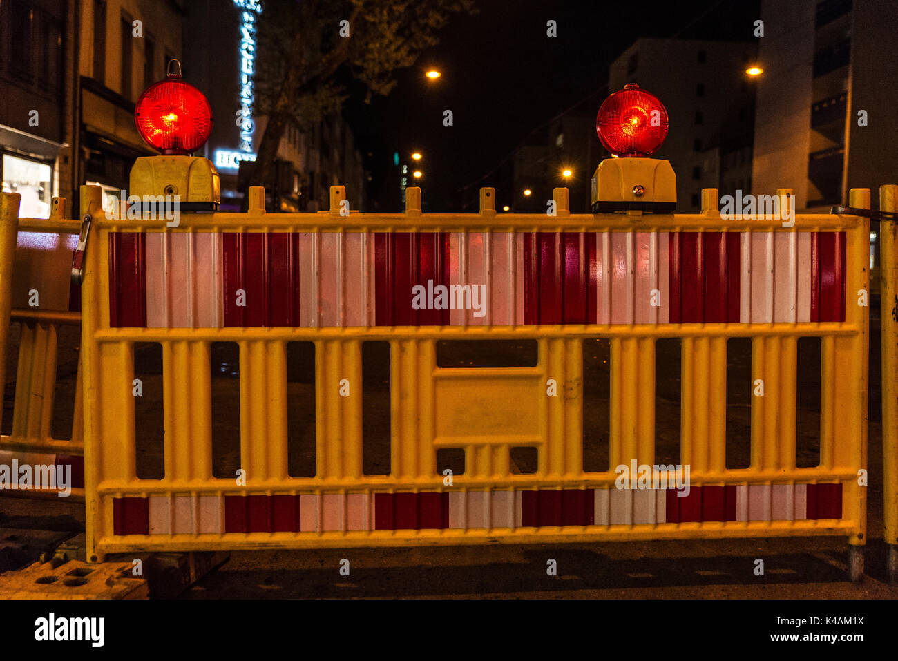 Fence with red warning lights warning of a street under construction in ...