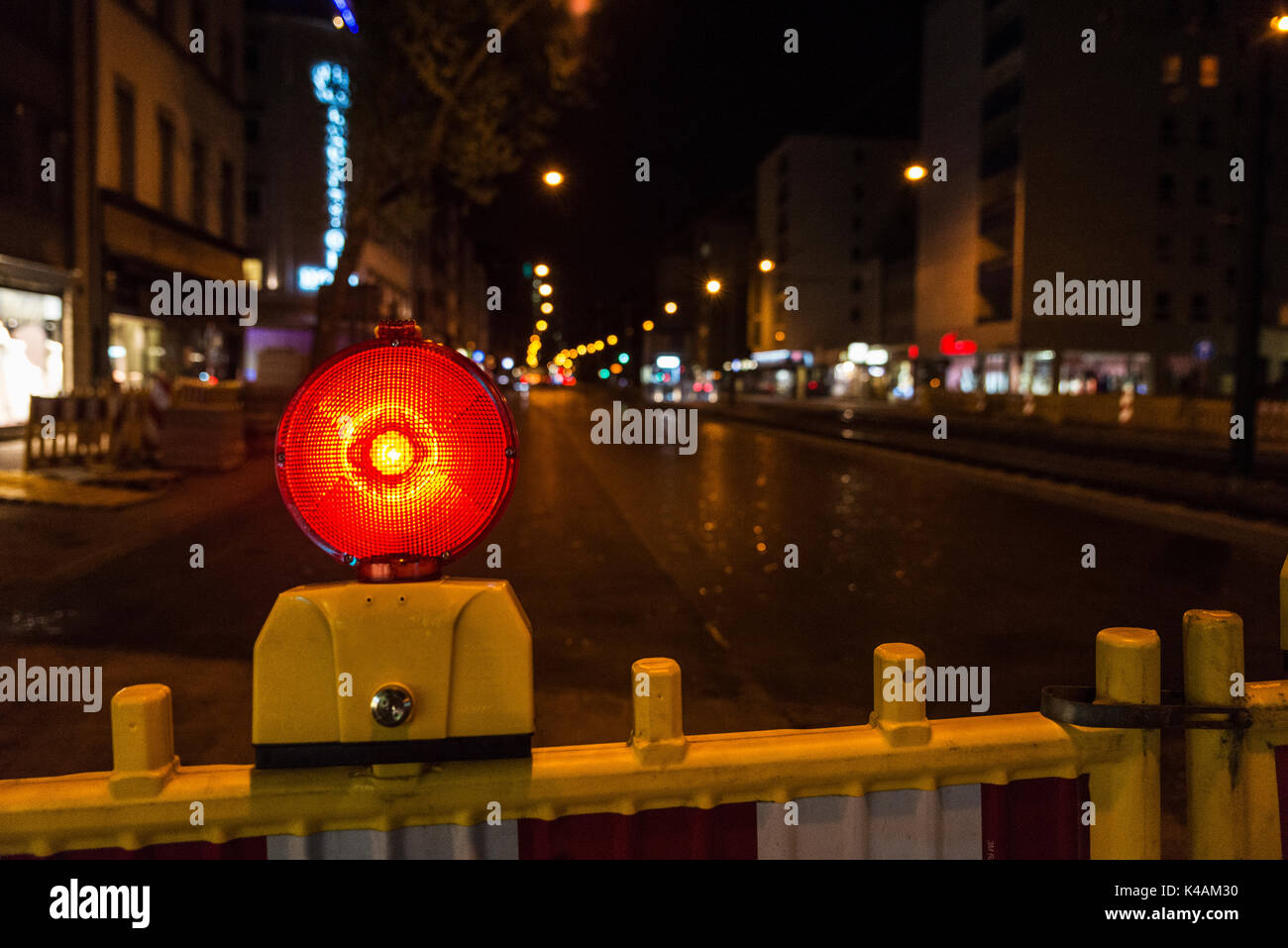 Fence with red warning light warning of a street under construction in ...