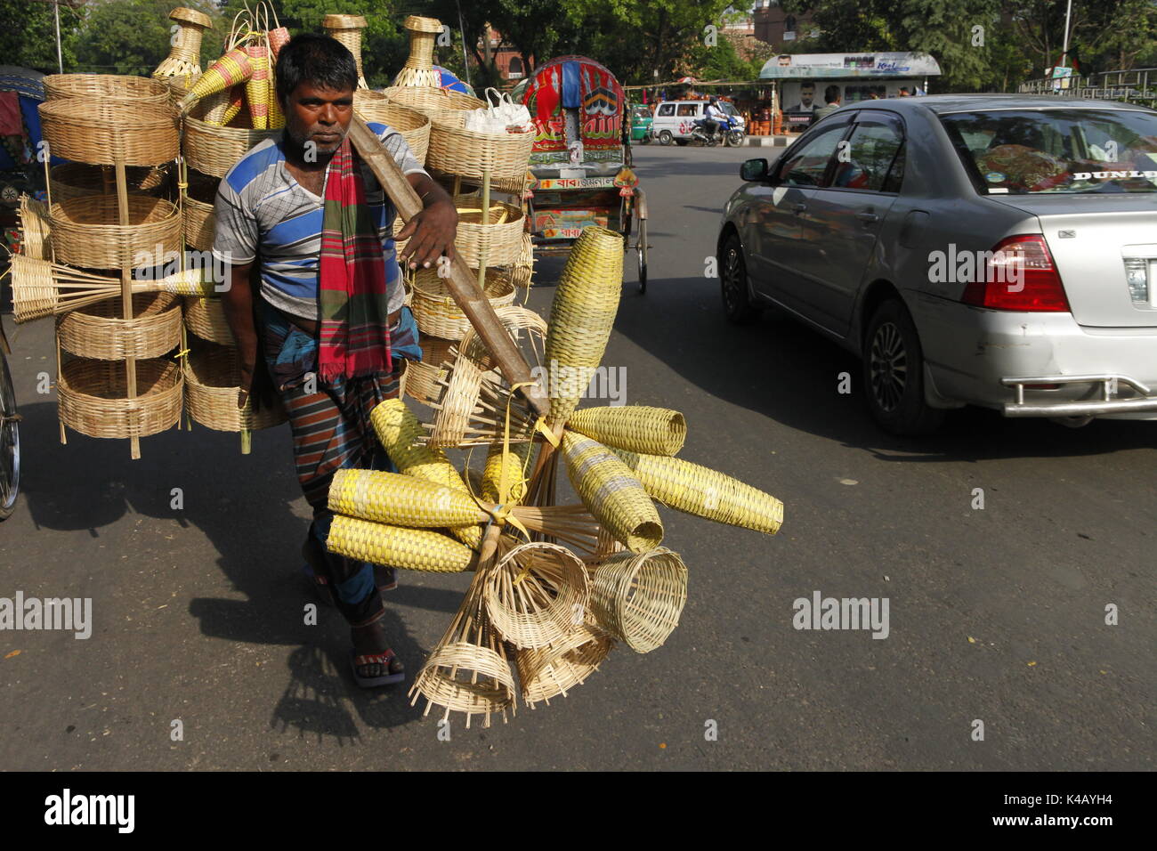 A man carrying traditional bamboo made handicrafts in Dhaka, Bangladesh ...