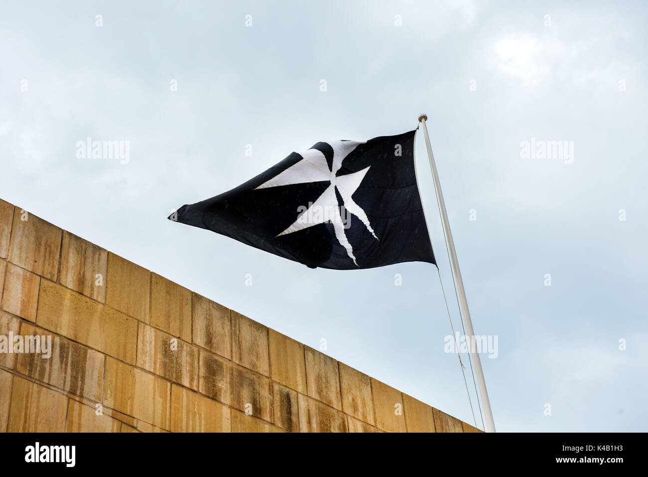 Symbol of the Order of Saint John, the Maltese cross on a black flag ...