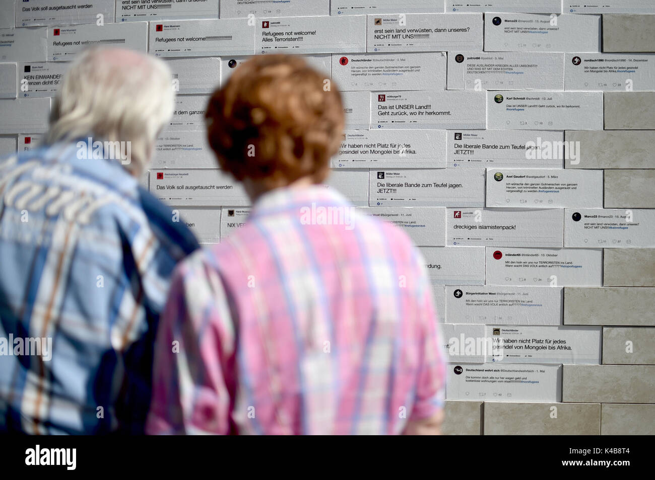 People look at a wall made of styrofoam blocks on which 'hate speech ...
