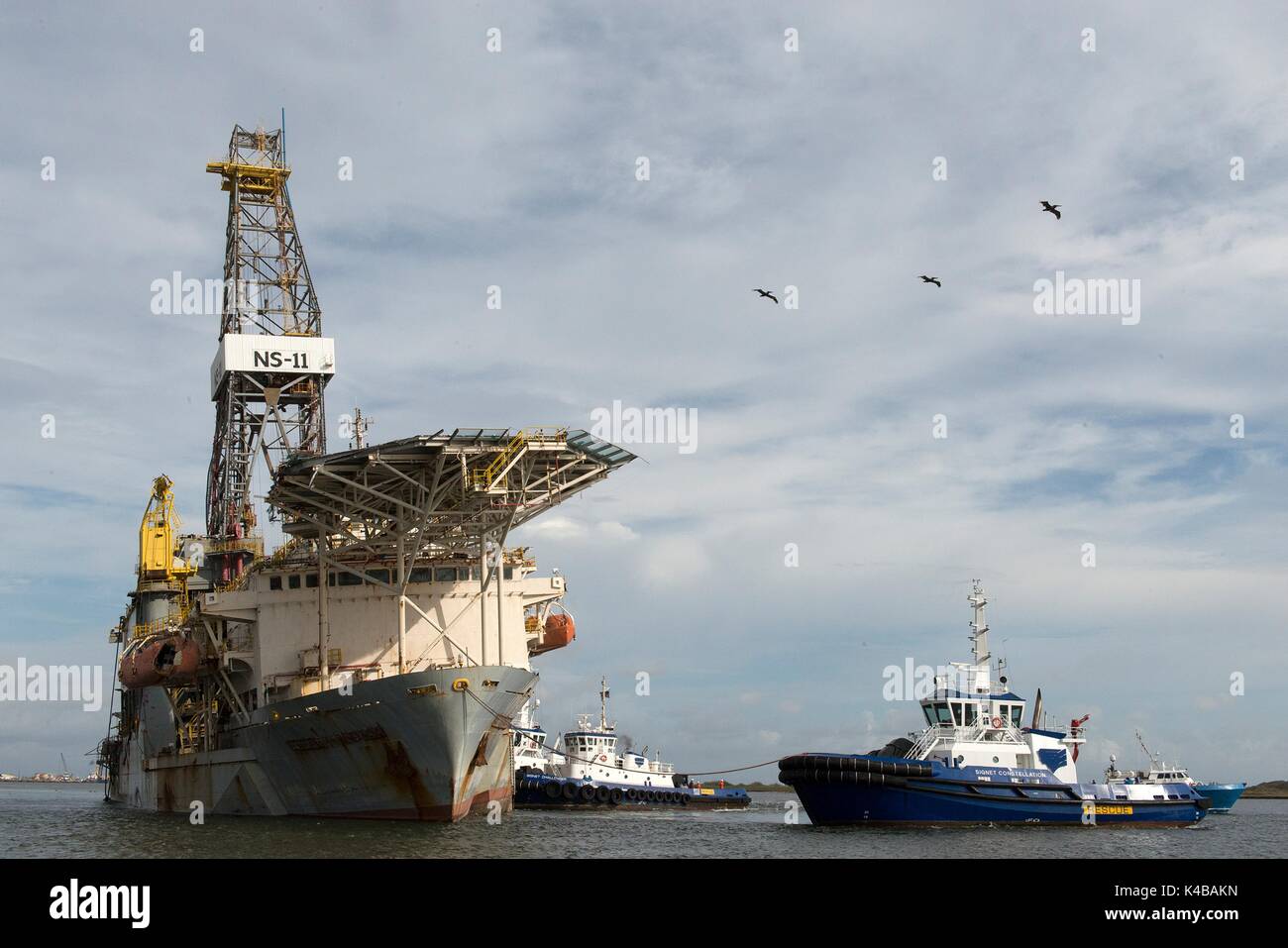 Rescue and salvage tug boats pull the grounded drill ship Paragon DPDS1 ...