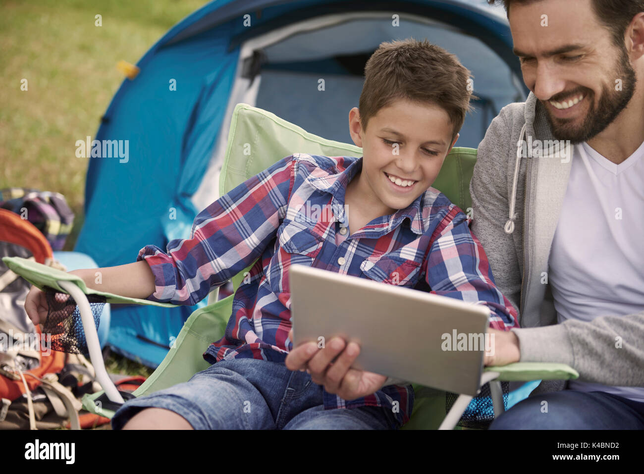 Father and son browsing the Internet on the camping Stock Photo - Alamy