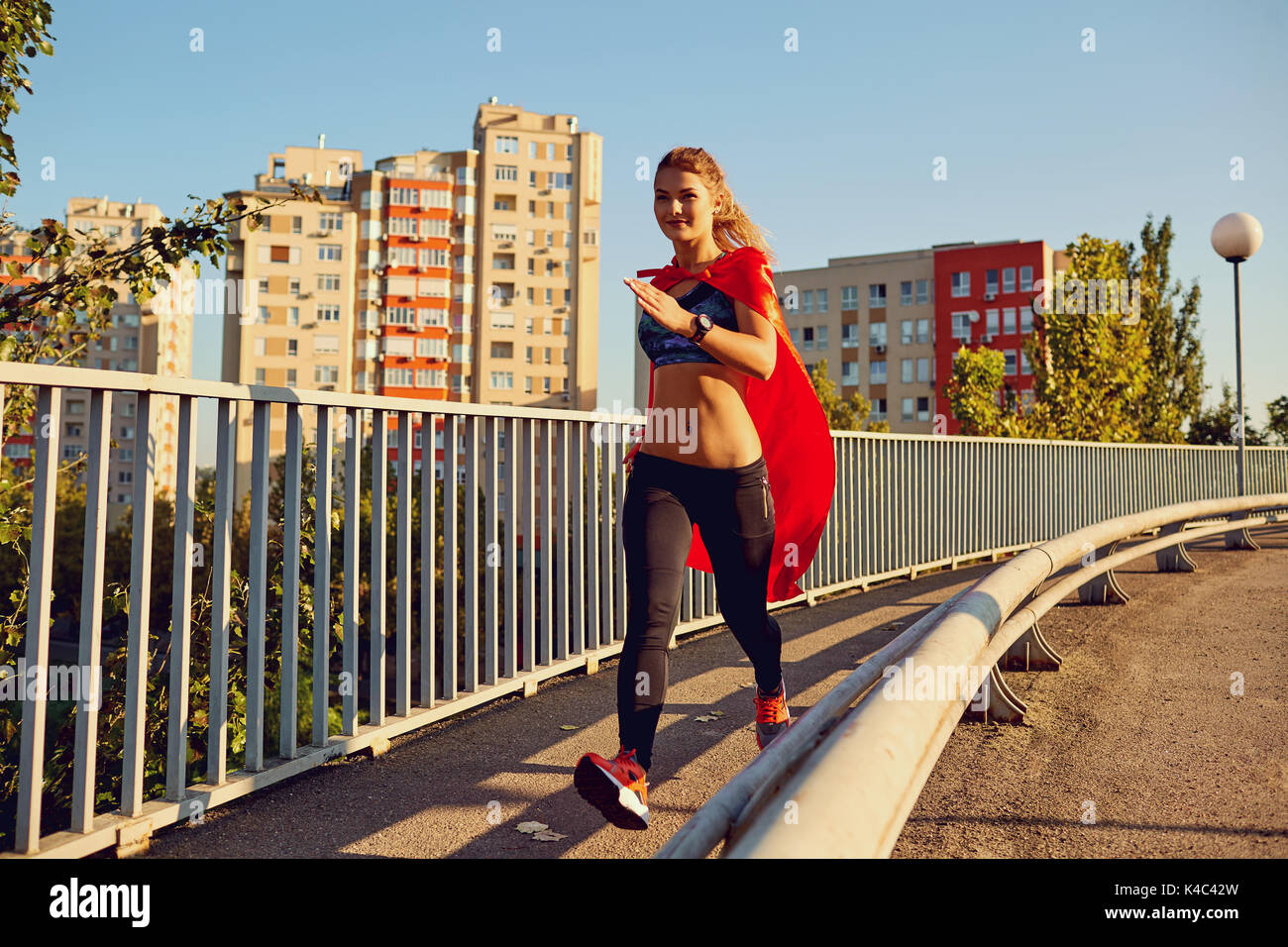 Girl runner in a superhero costume runs along the road Stock Photo - Alamy