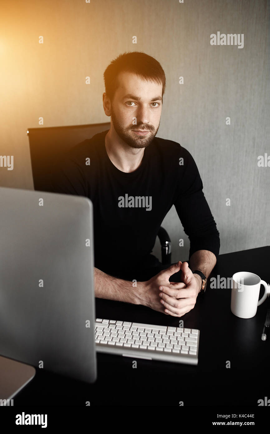 Smart businessman at workplace in office holding his head on hands ...