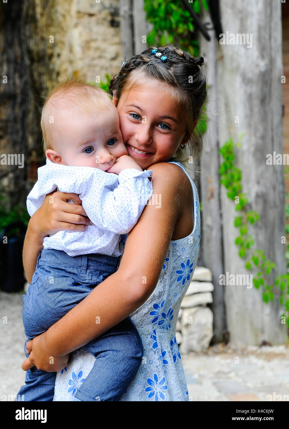 little laughing girl with her brother on a summer day at a celebration ...
