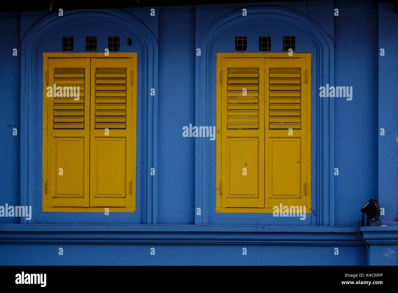 Blue Facade With Closed Yellow Window Shutters Stock Photo - Alamy