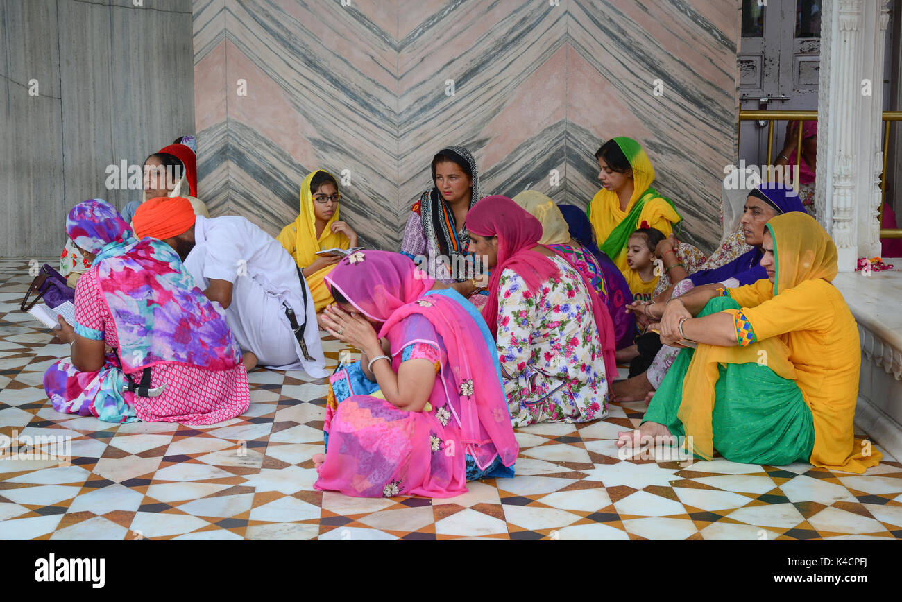 Amritsar, India - Jul 25, 2015. Sikh women praying at the Golden Temple ...