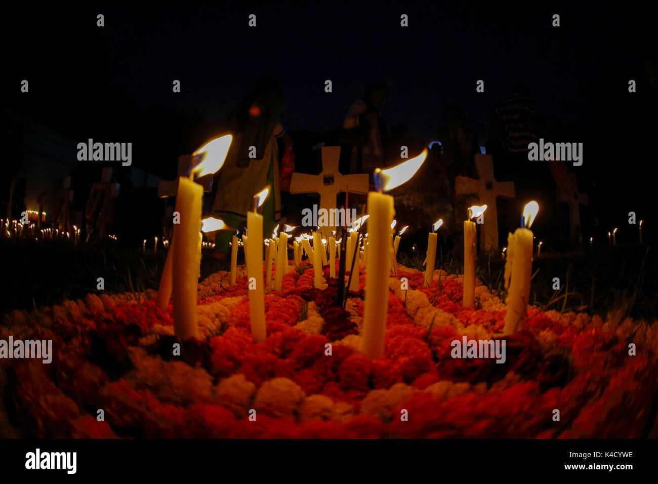 Family members light candles and put them on the graves of their loved ...