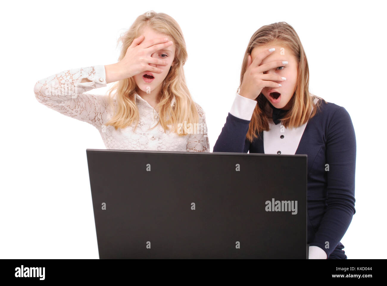 Two shocked girls using laptop isolated on a white background Stock ...