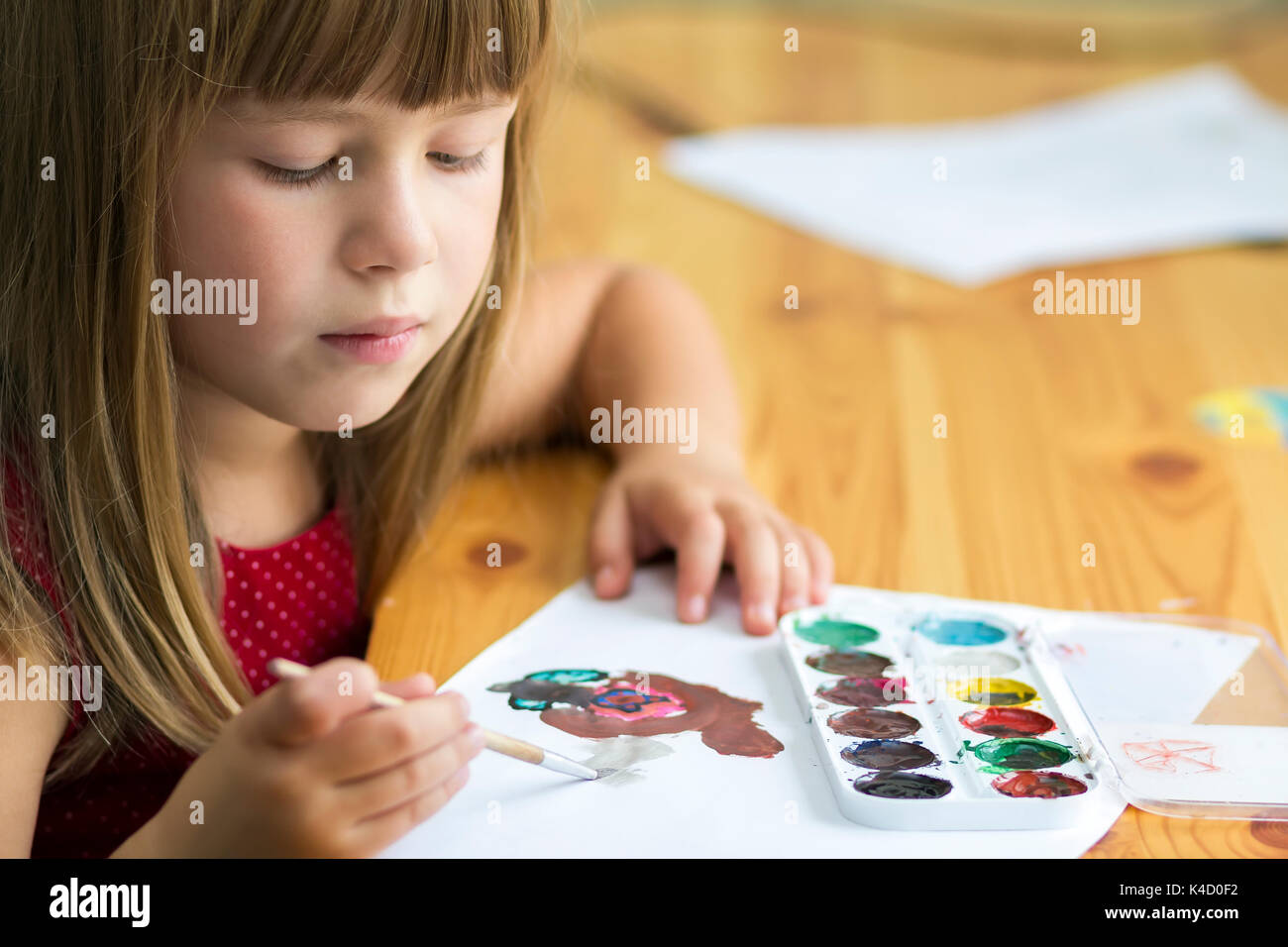 Cute little child girl painting with paintbrush and colorful paints ...